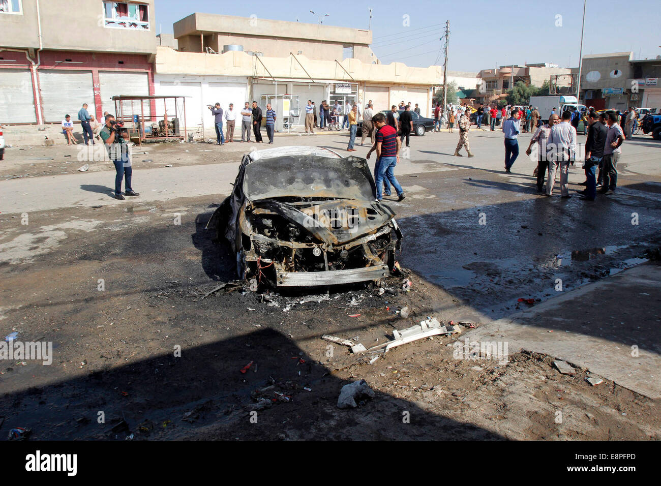 Kirkuk, Iraq. 13th Oct, 2014. People gather at the site of a bomb ...
