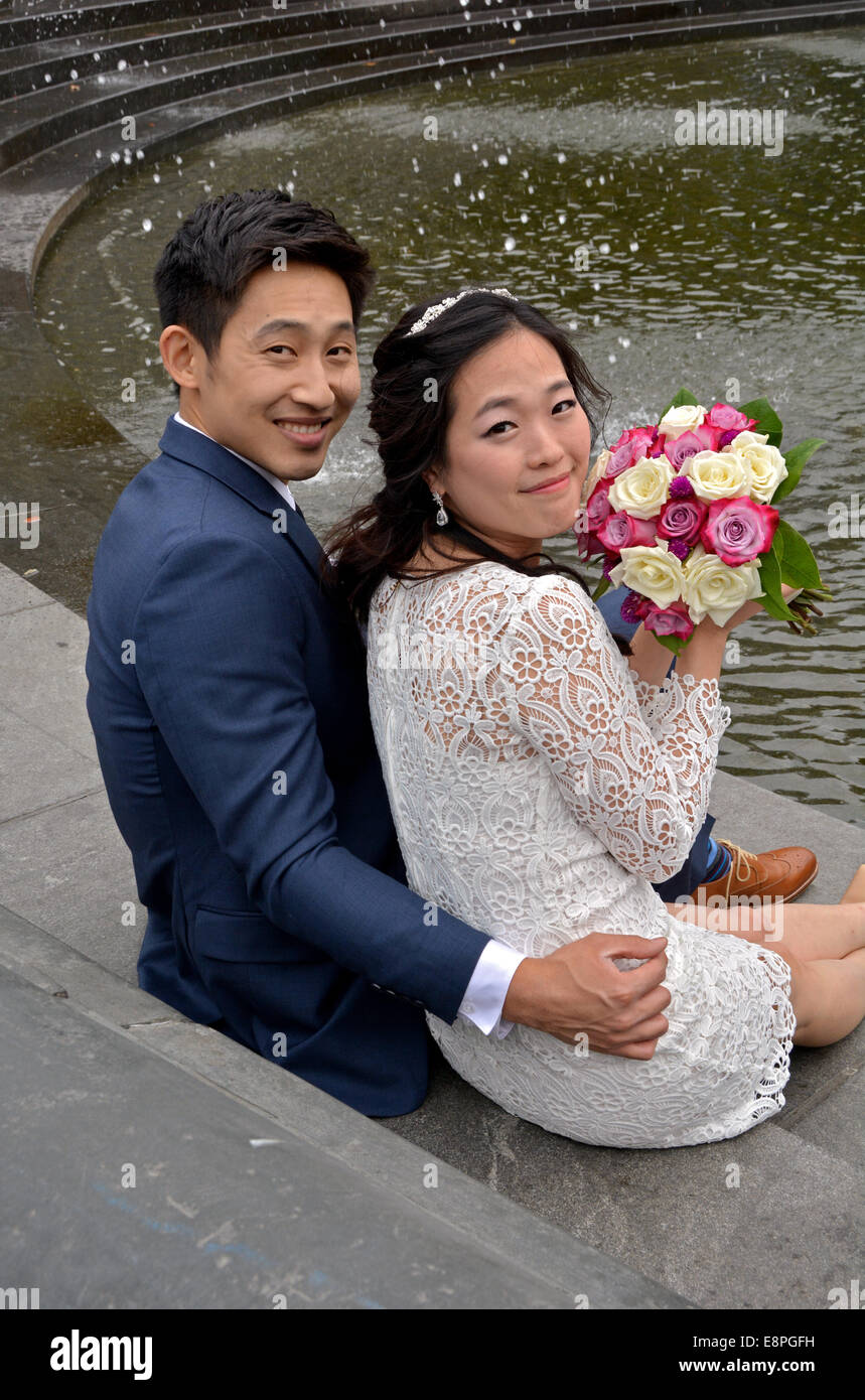 Portrait of an engaged Asian couple at the fountain in Washington ...