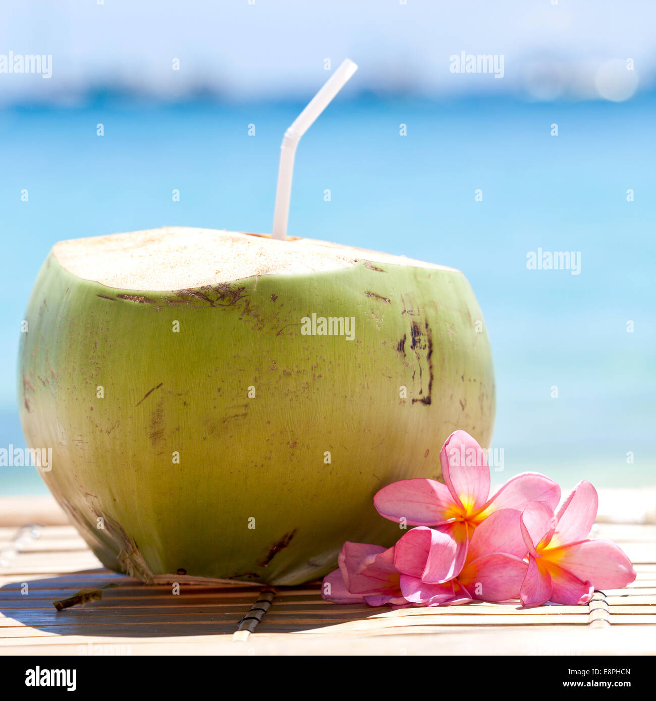 Tropical fresh coconut cocktail decorated plumeria on white beach Stock ...