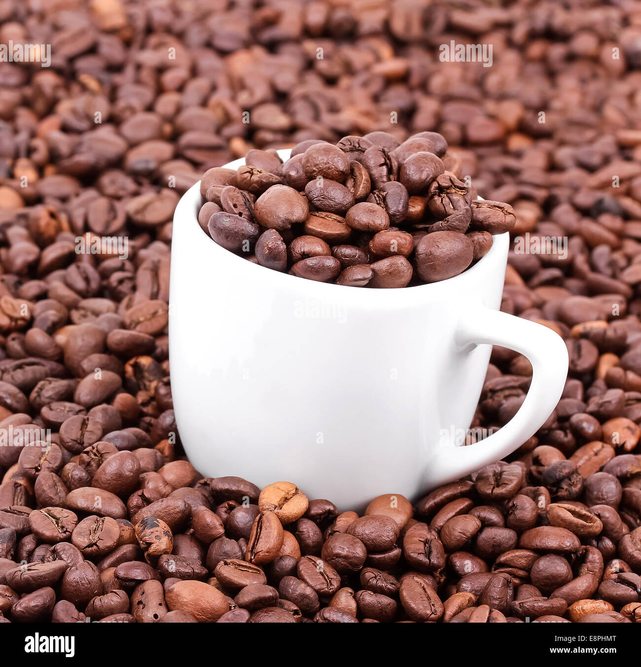 White cup with coffee beans, closeup Stock Photo - Alamy