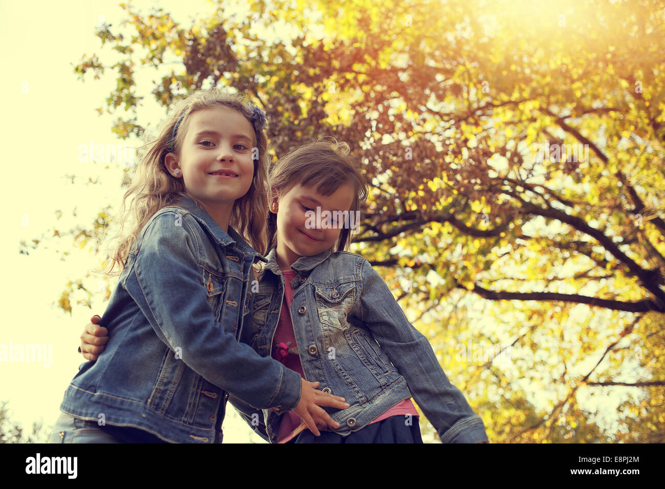 Two young girls having fun in the autumn sunny day Stock Photo - Alamy
