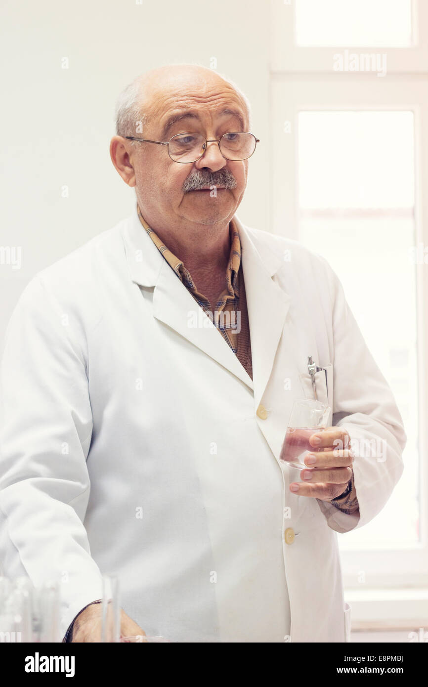 Portrait of an old scientist holding chemical Stock Photo - Alamy