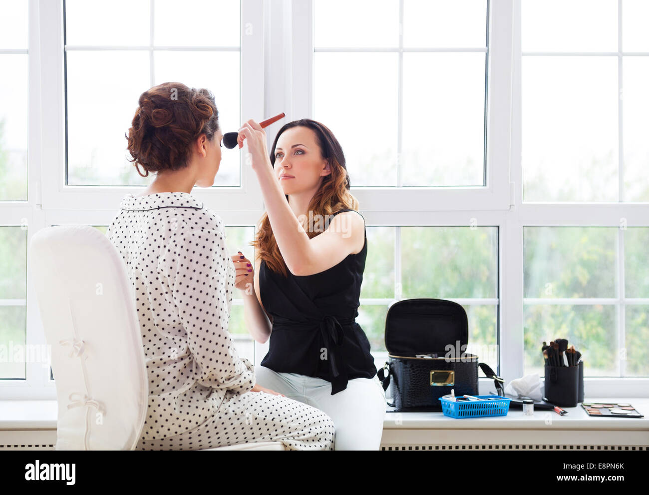 Make-up artist doing make up for young beautiful bride applying wedding ...