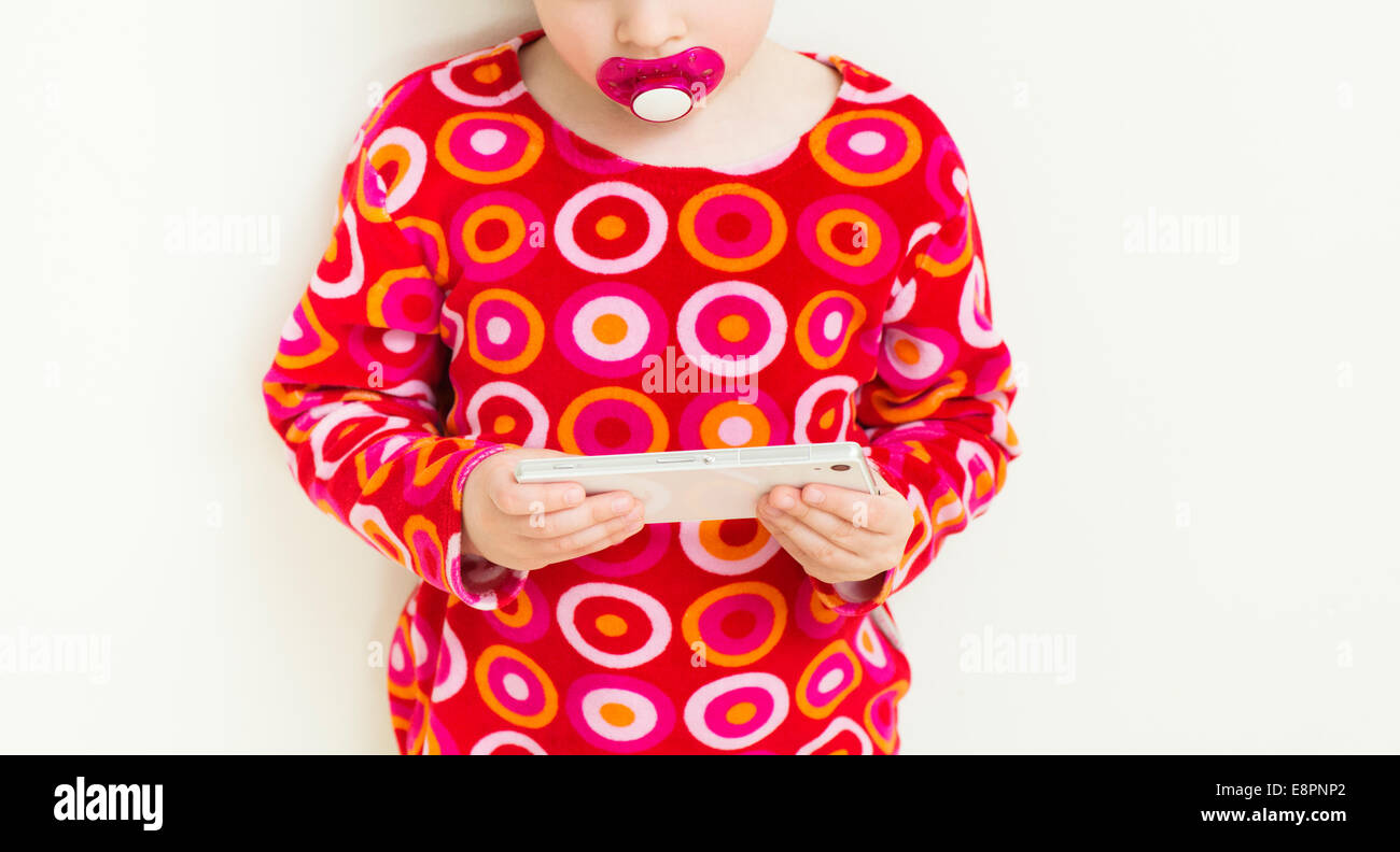 Little girl with red dress and pacifier holding smart phone Stock Photo ...