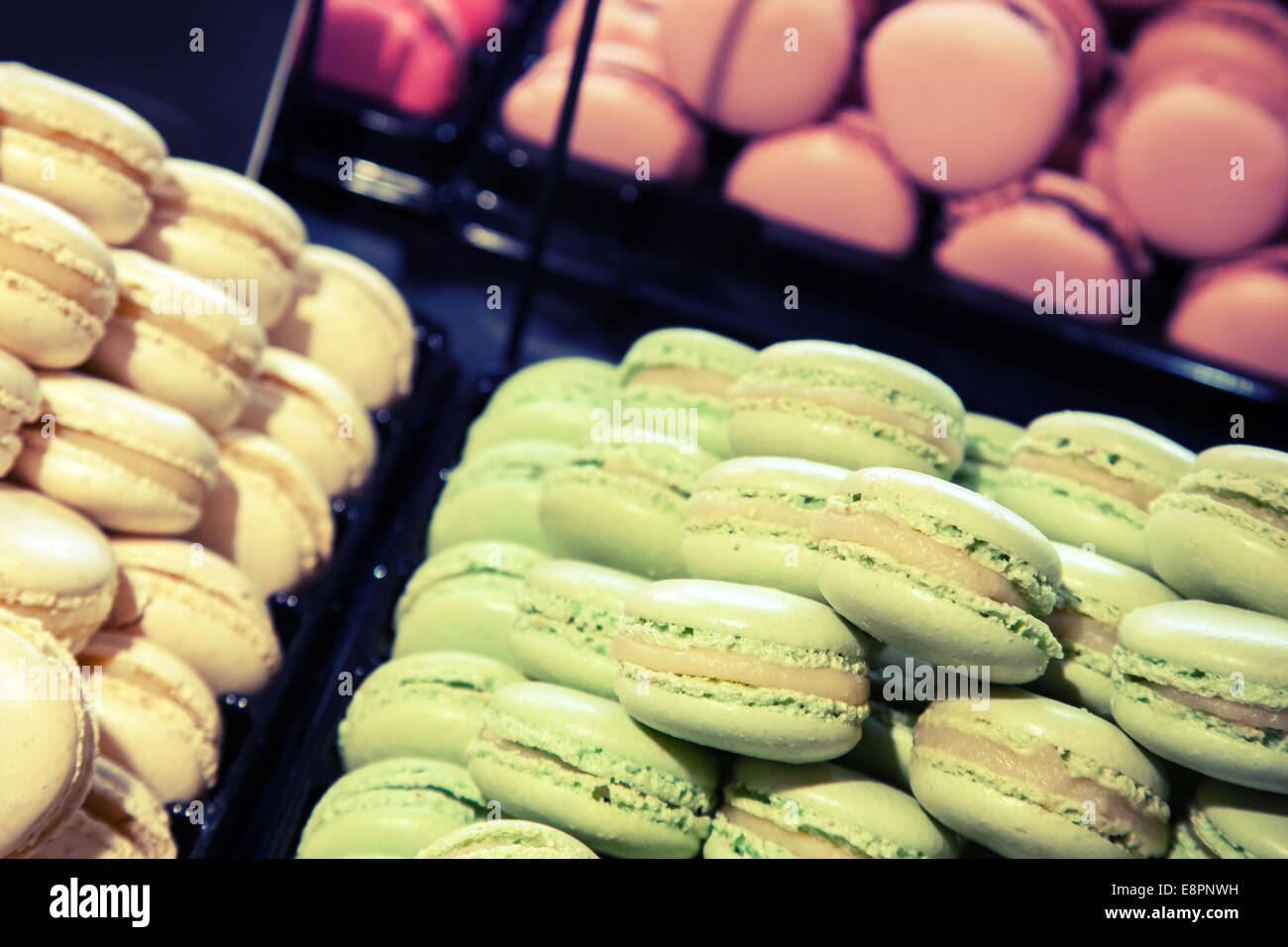 Colorful traditional French macarons lay in the bakery. Toned photo ...