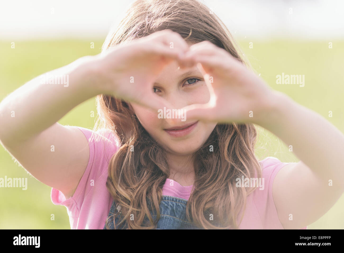 girl making a love heart sign, focus on her eye through her hands Stock ...