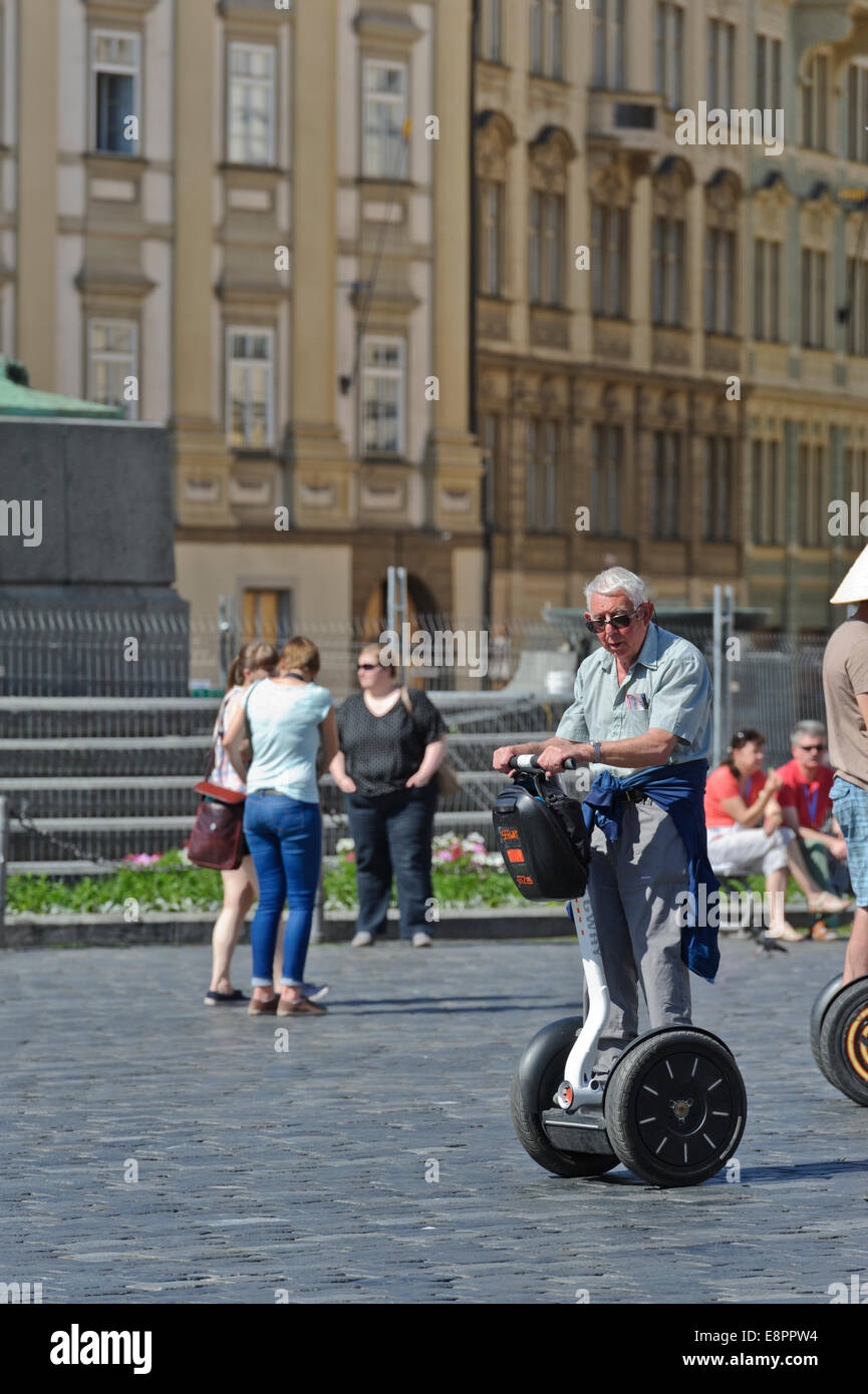 A elderly man riding on a motorized Segway in the Old Town Square ...