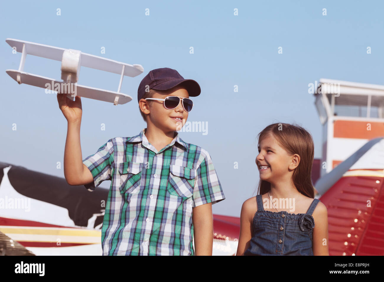 Little boy and little girl pilot with handmade plane at the airport ...