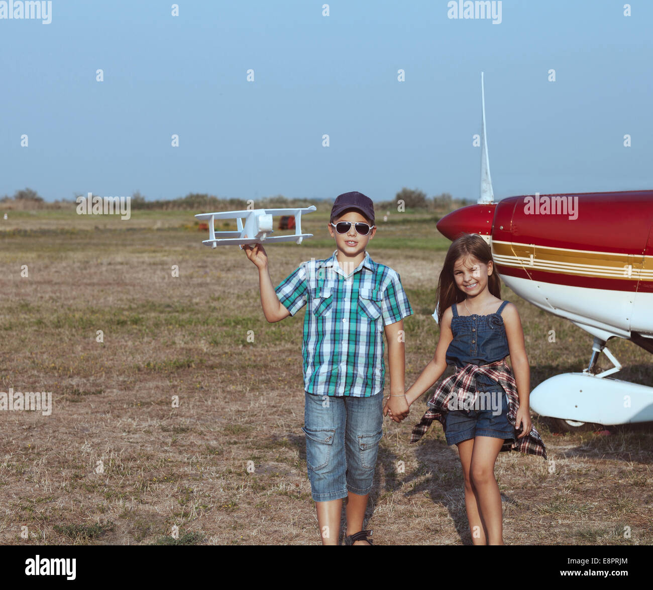 Little boy and little girl pilot with handmade plane at the airport ...