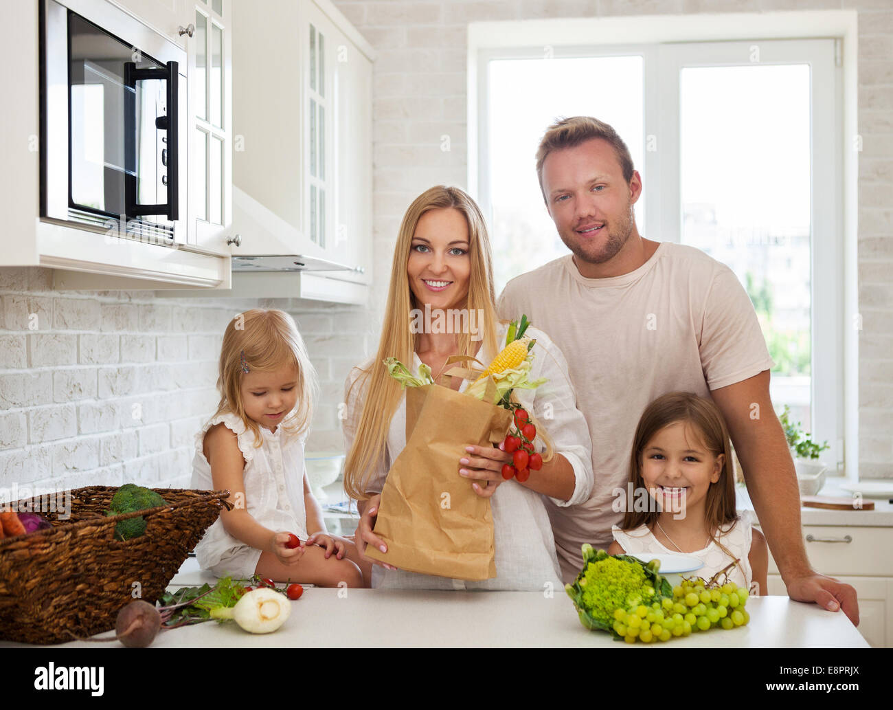 Young family cooking in a modern kitchen setting Stock Photo - Alamy