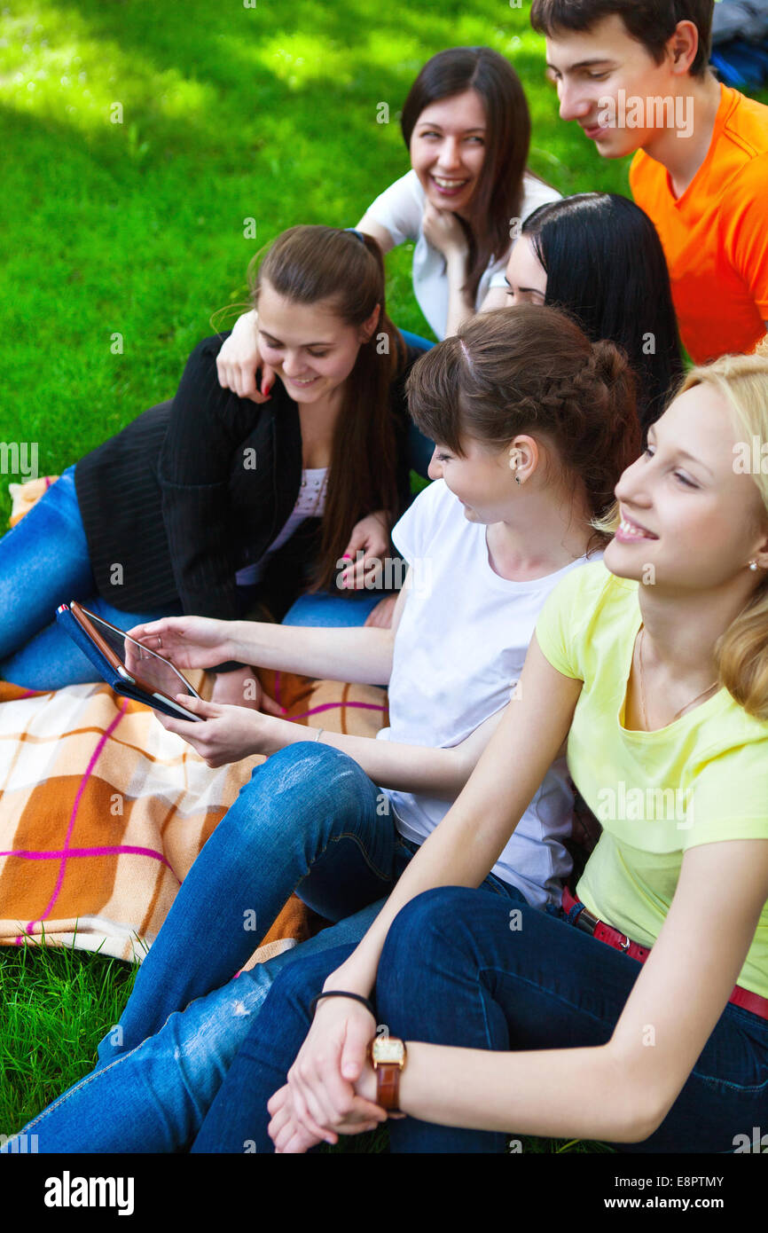 Young college students using tablet computer while doing homework in ...