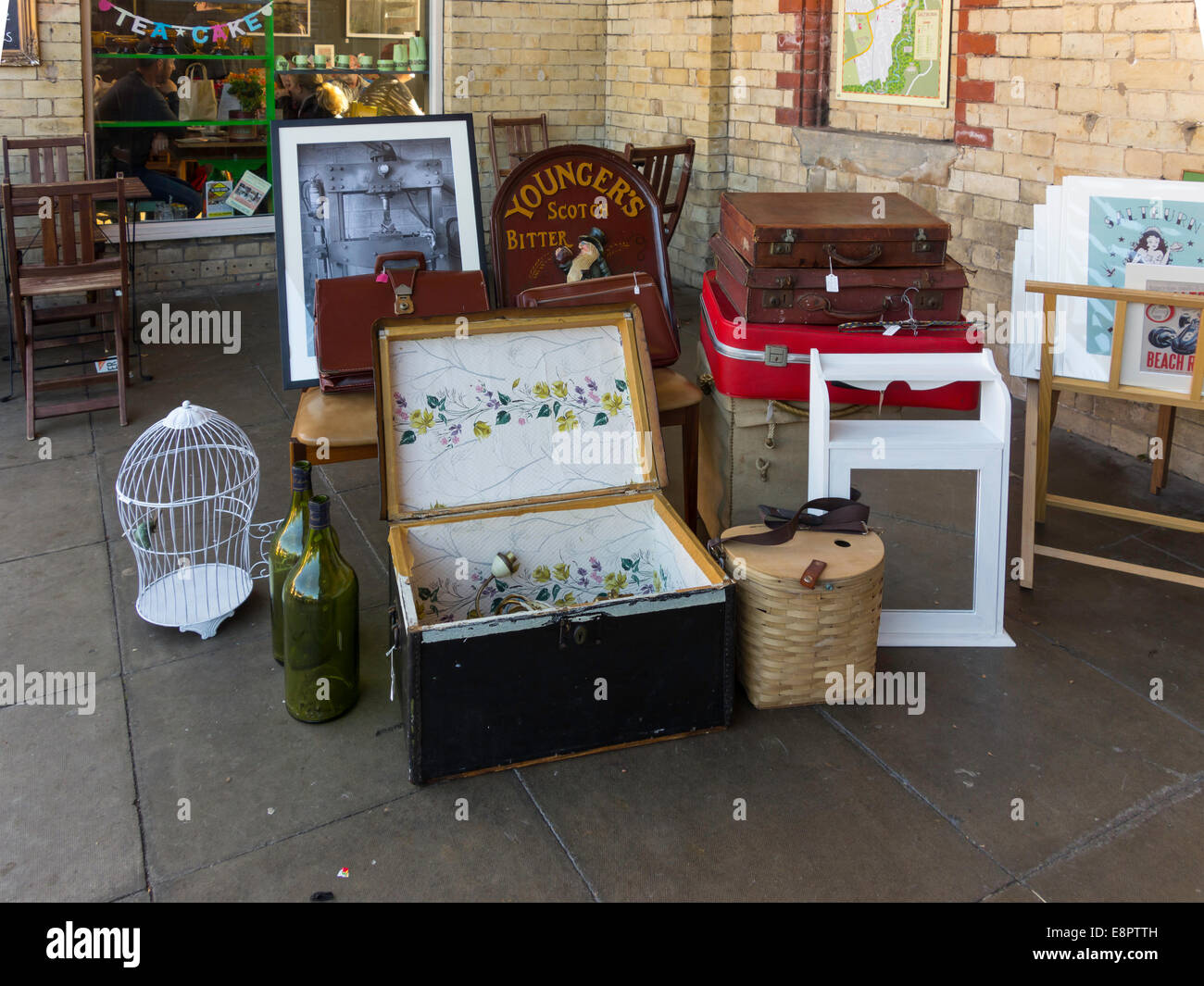 A collection of historic luggage and household items for sale outside ...