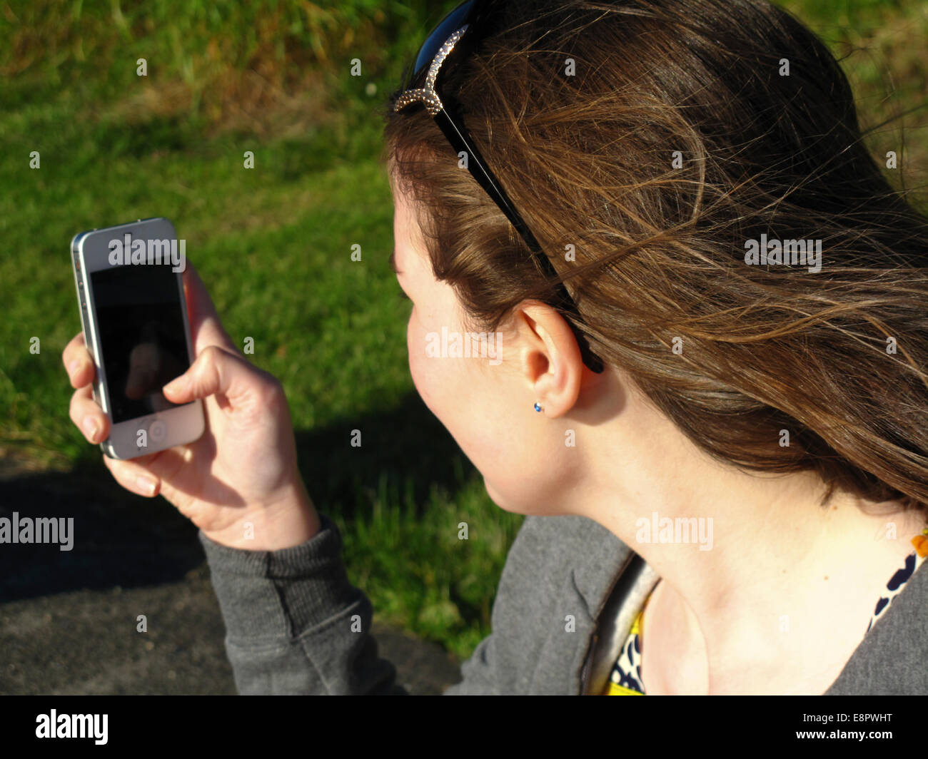 Young teenage girl using iPhone in strong sunlight Stock Photo - Alamy