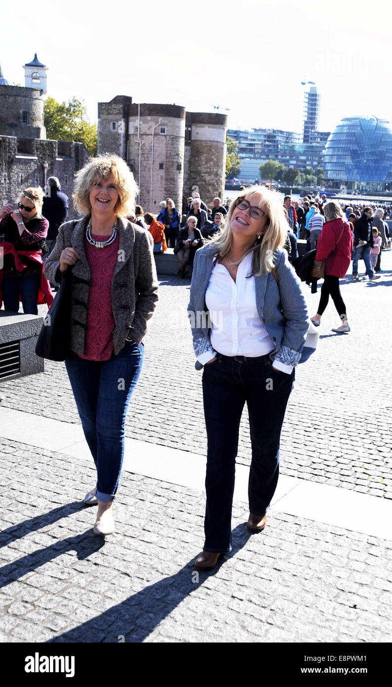 London UK - Two middle aged women friends walking laughing by Tower of ...