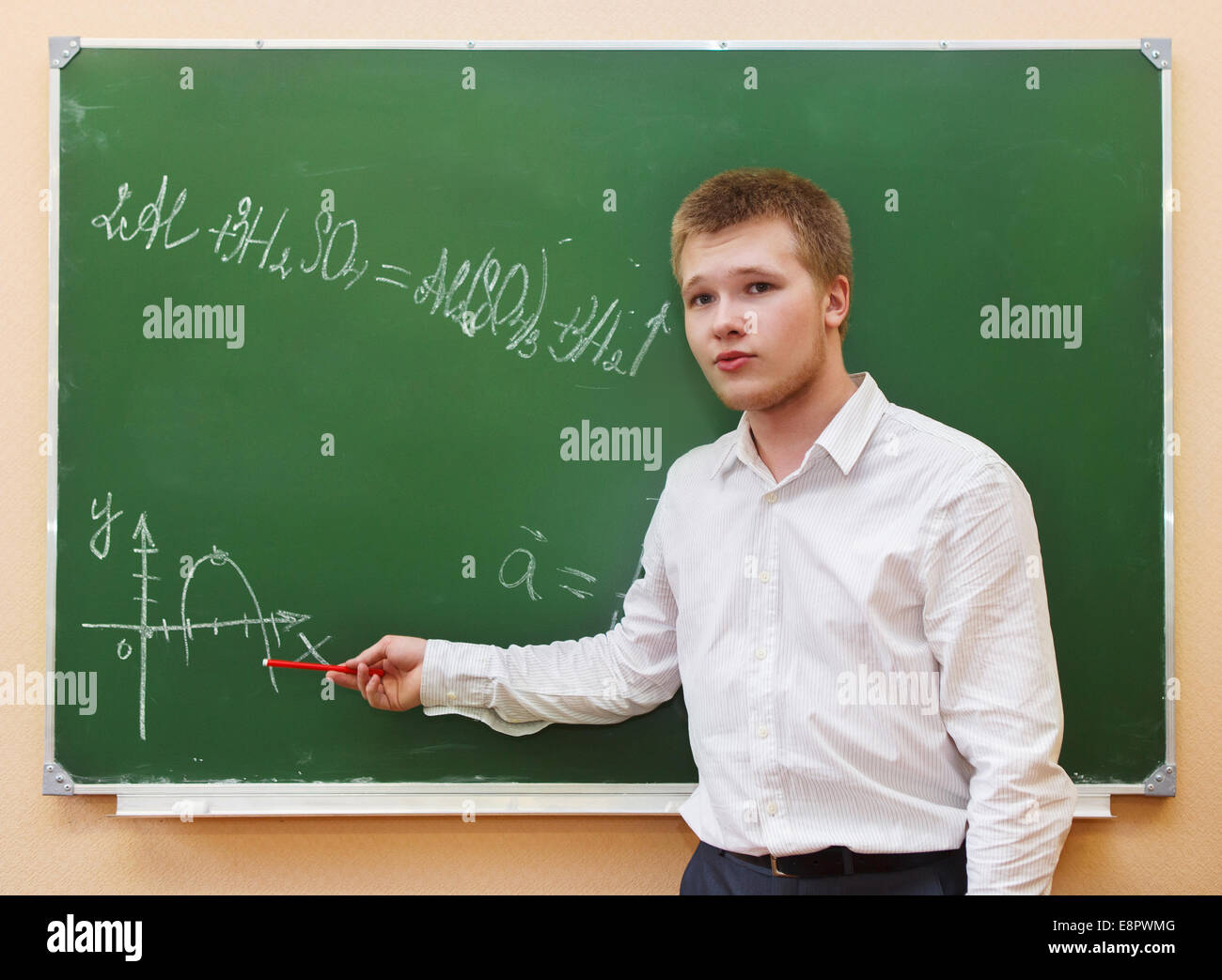Student boy standing near the blackboard in the classroom Stock Photo ...
