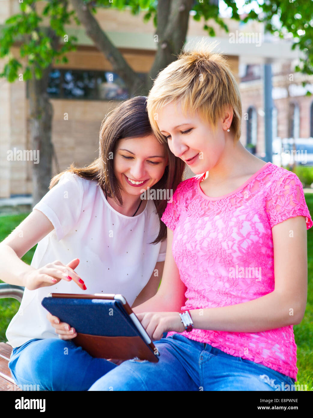 Young college students using tablet computer while doing homework in ...