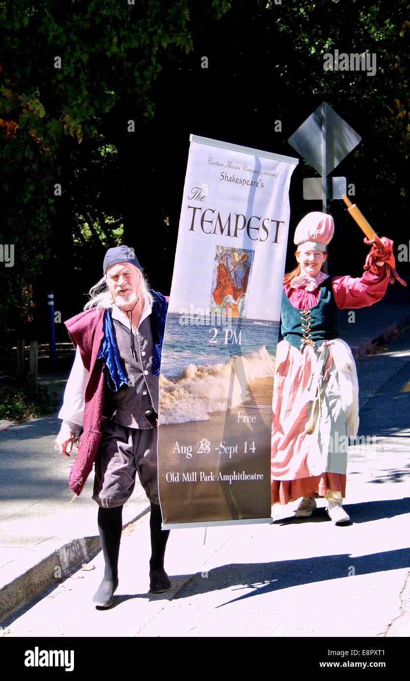 two street performers carry sign advertising coming theater performance ...