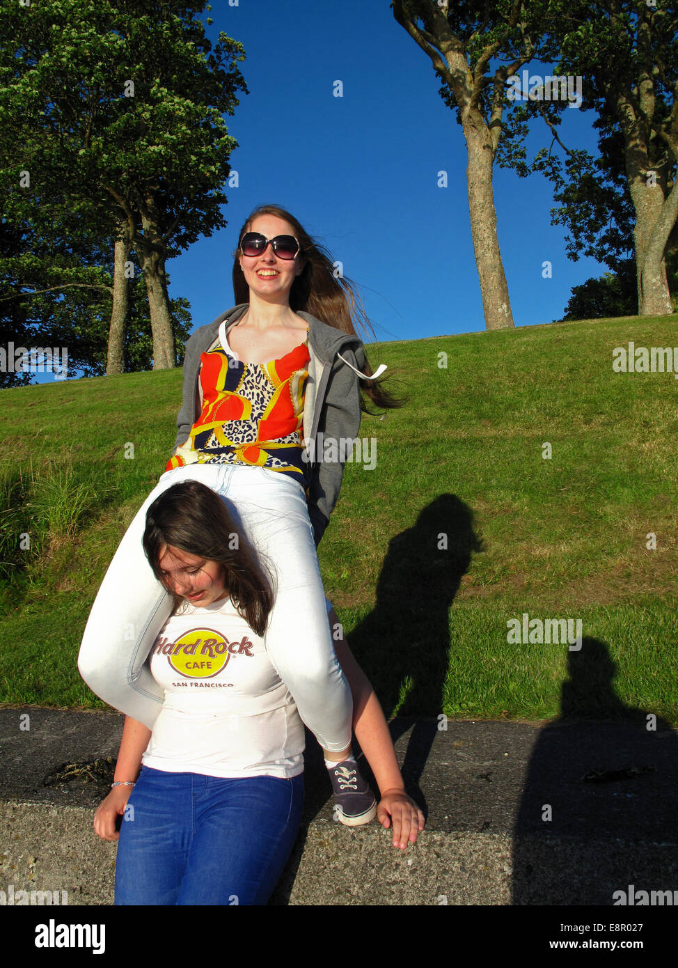 Girl on other girl's shoulders laughing Stock Photo - Alamy