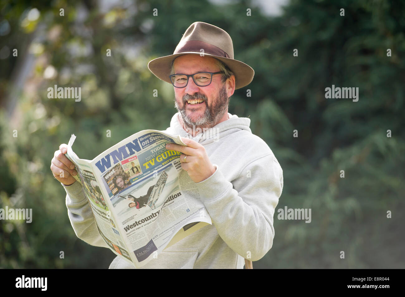 Historical crime author Michael Jecks, Devon UK reading a local paper ...