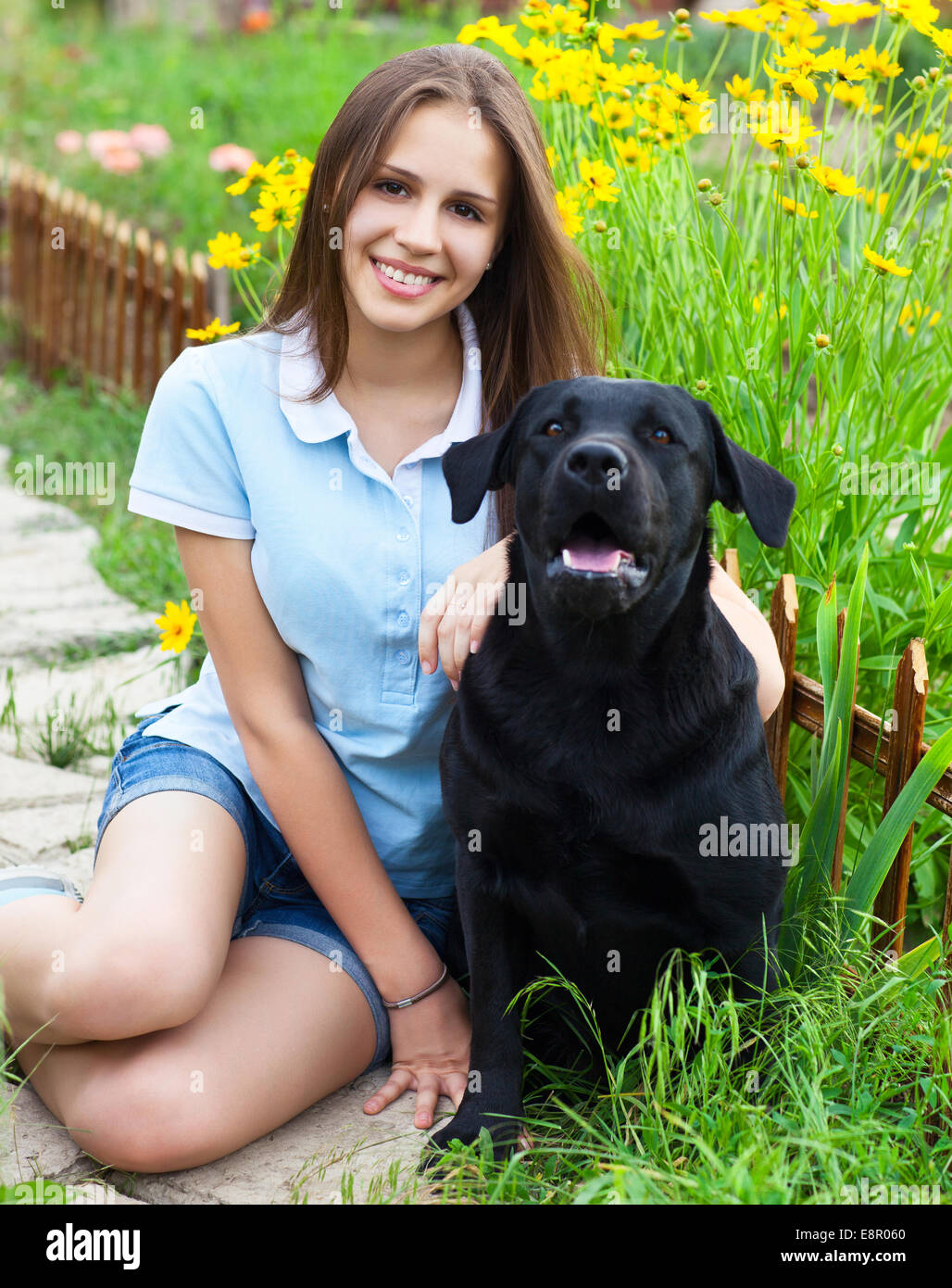 Teenager girl with black labrador retriever dog outdoors Stock Photo ...