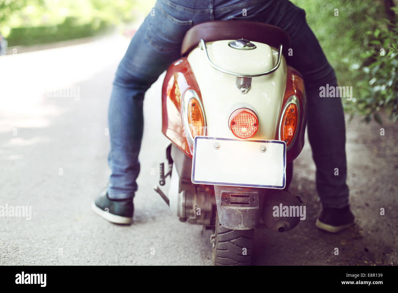 Man riding old retro scooter in a city street. Close up Stock Photo - Alamy