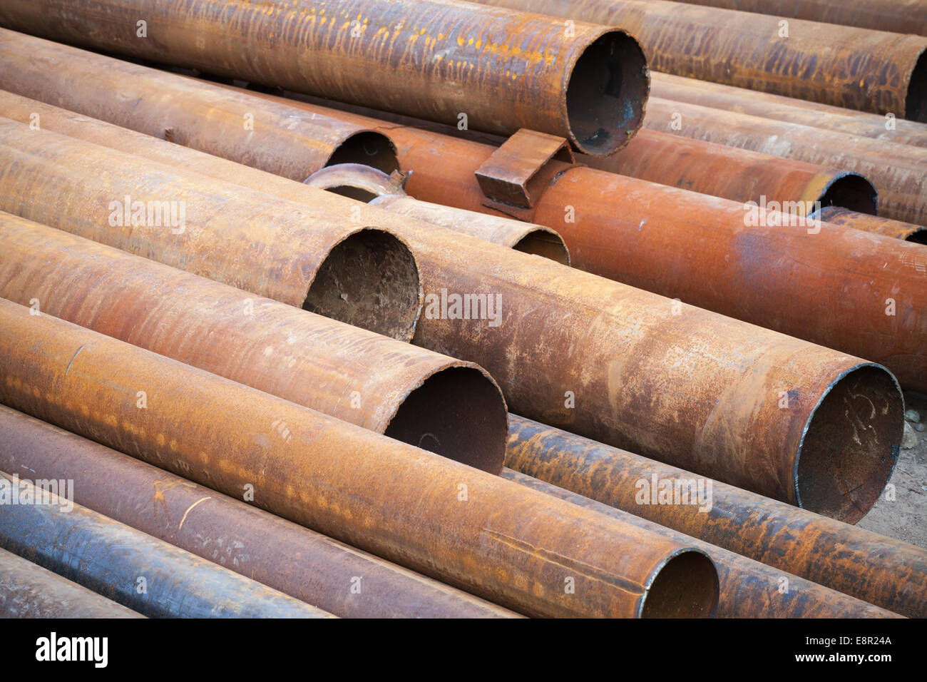 Pile of rusted industrial steel pipes lay on the ground Stock Photo - Alamy