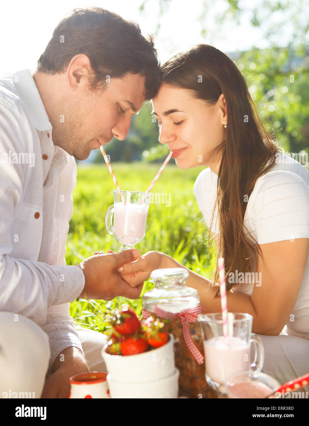 Young happy couple in love drinking milk shake at spring picnic in ...