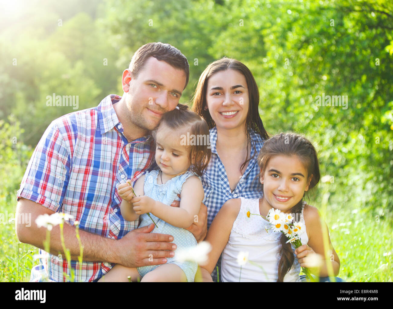 Happy young family with two children in the spring forest Stock Photo ...