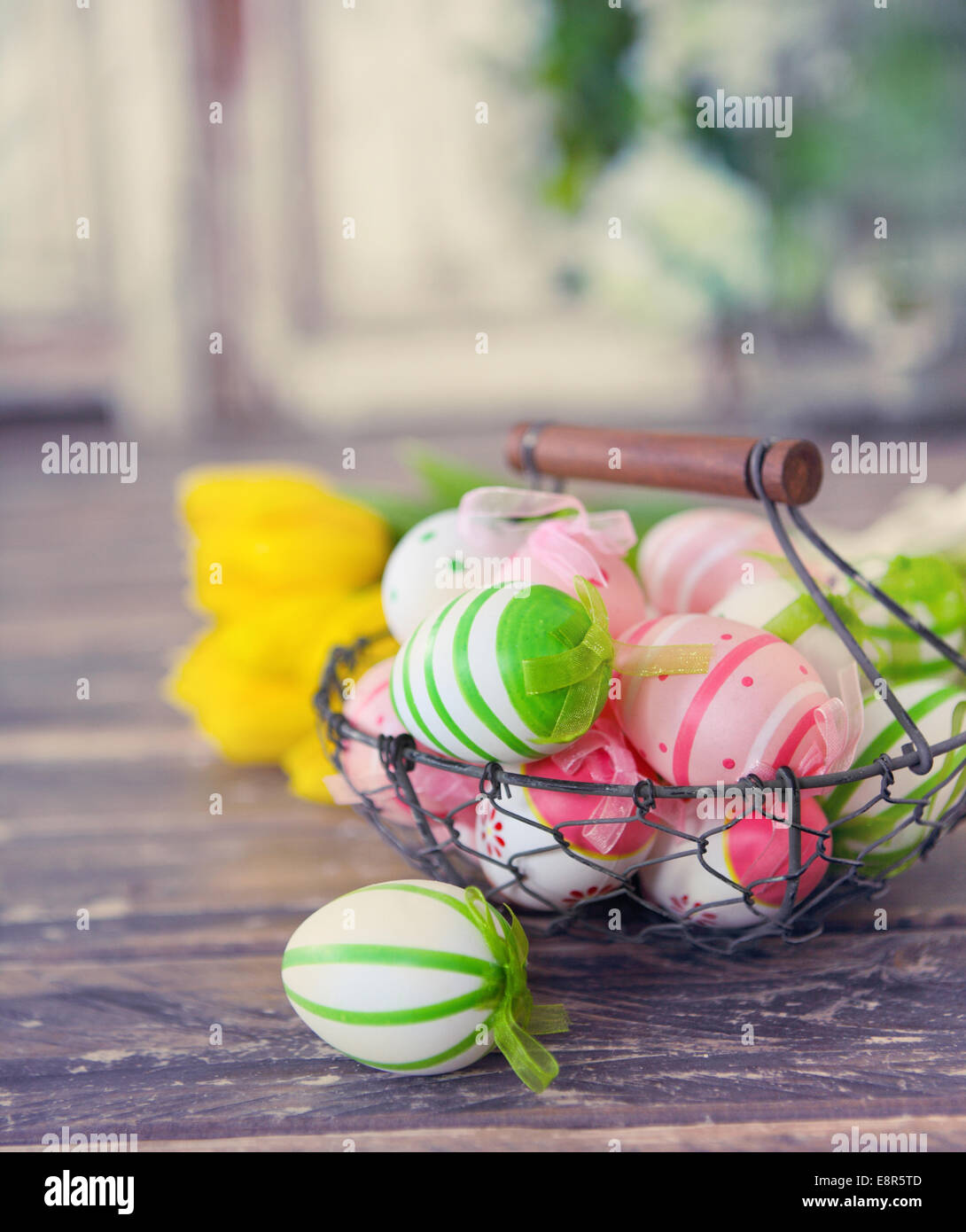 Pastel flowers, colorful Easter eggs in basket Stock Photo - Alamy