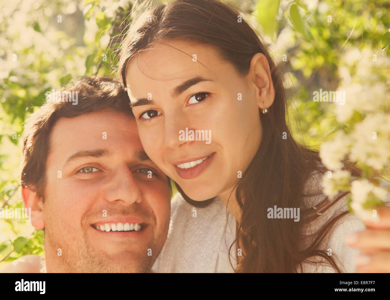 Young happy couple in love in the flowering spring park. Outdoors ...