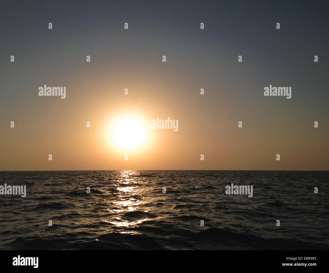 Beautiful sunset sky over the navy blue ocean Stock Photo - Alamy