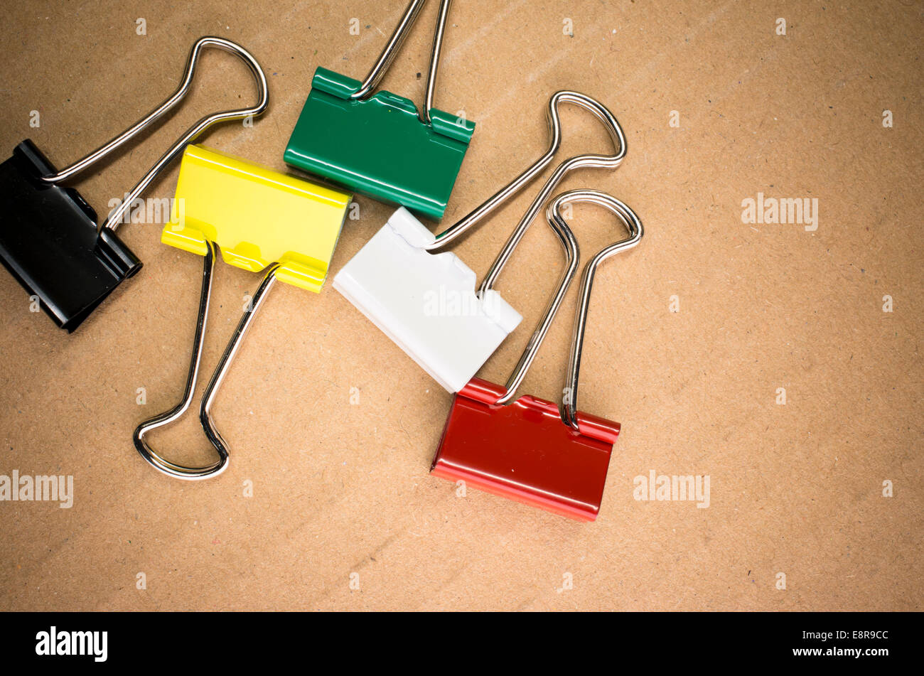 colored metal paper clips on a cardboard background Stock Photo - Alamy