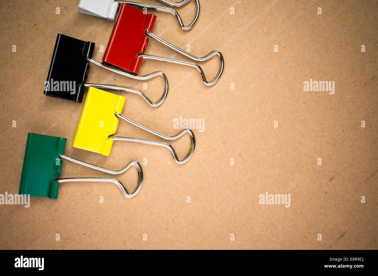 colored metal paper clips on a cardboard background Stock Photo - Alamy