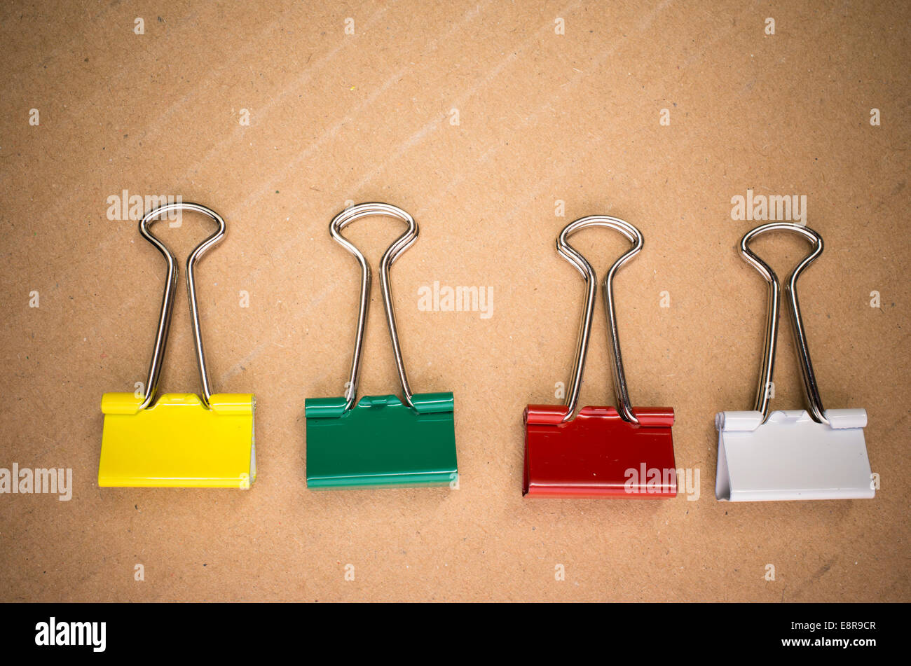 colored metal paper clips on a cardboard background Stock Photo - Alamy