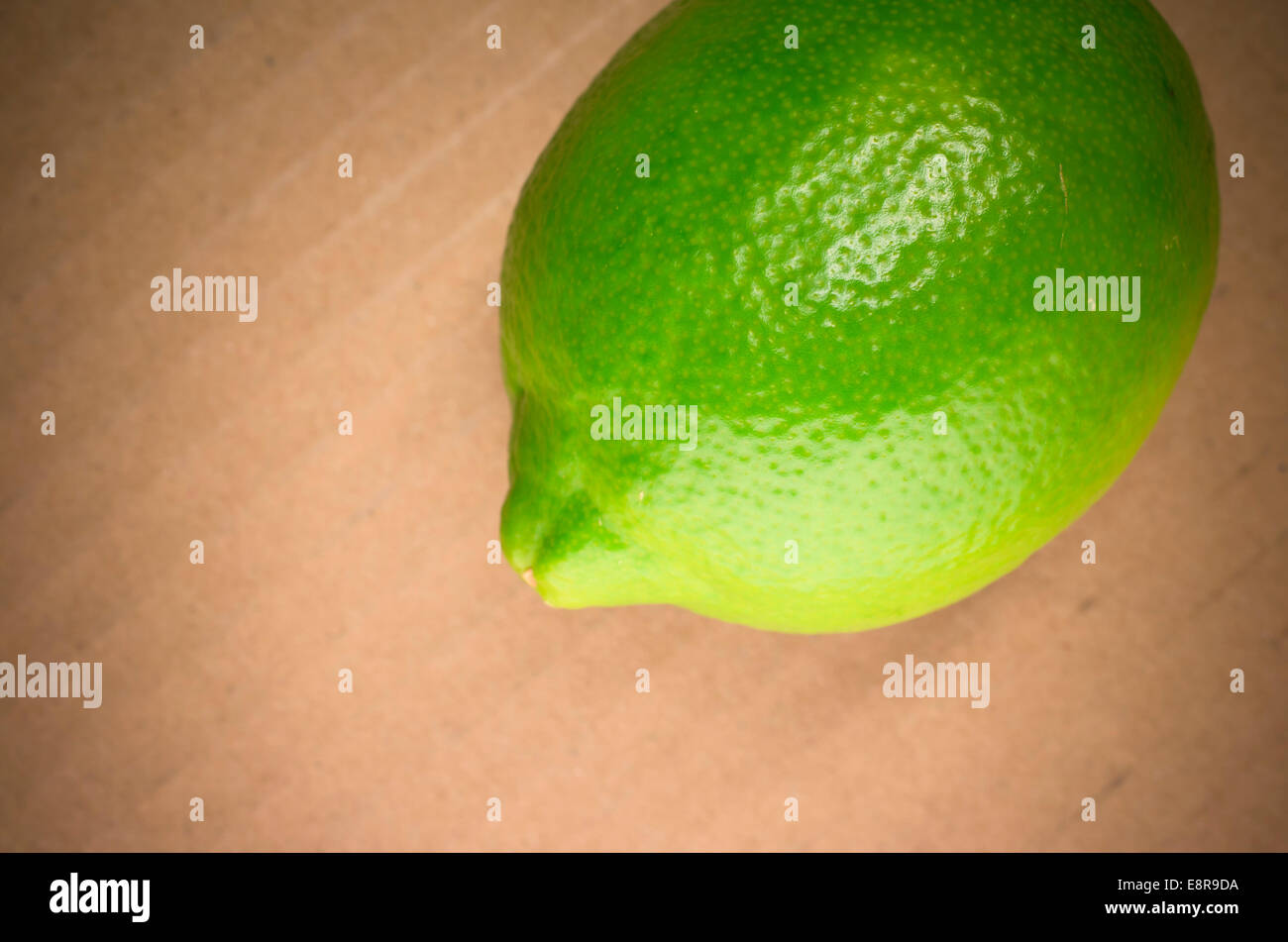 green lemon on a cardboard surface Stock Photo - Alamy