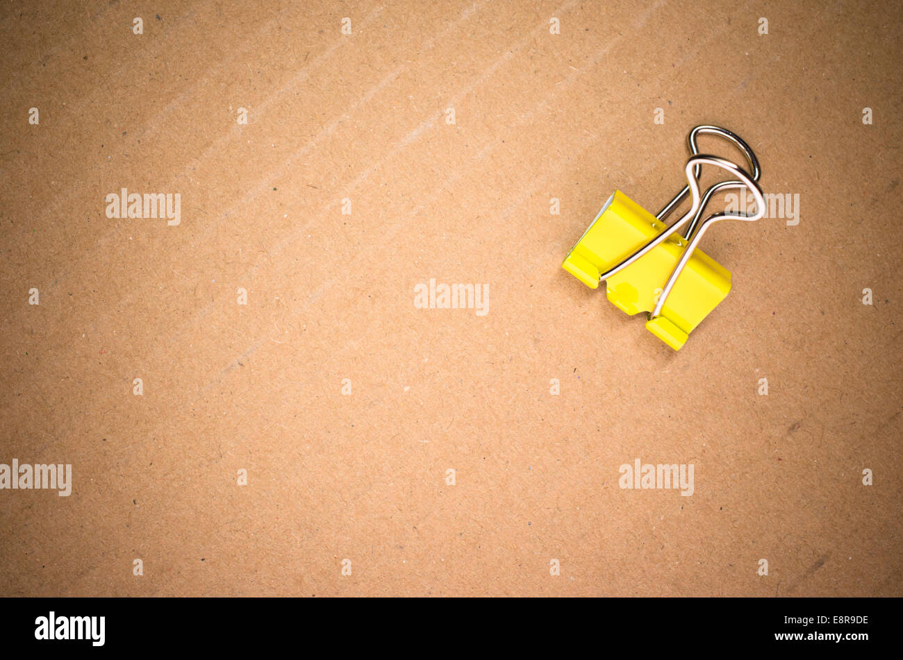 yellow metal paper clip on a cardboard background Stock Photo - Alamy