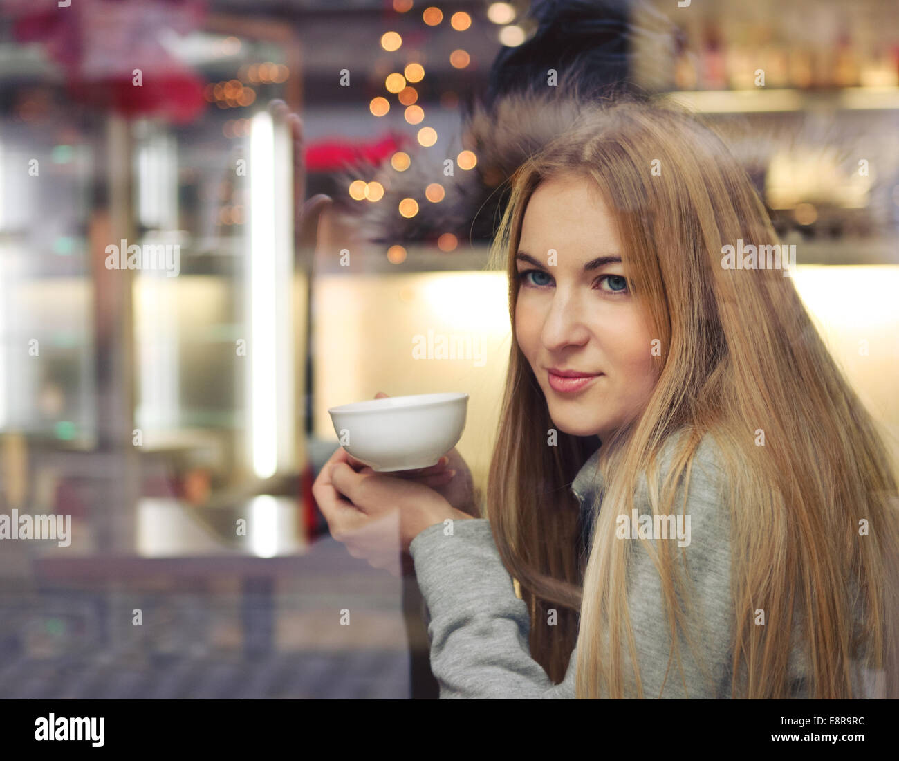 Smiling blond woman drinking tea in cafe Stock Photo - Alamy