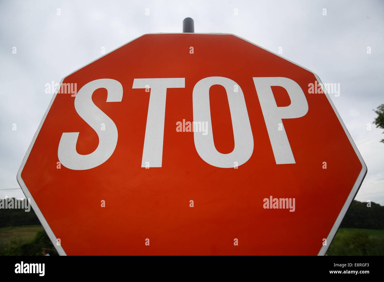 Color detail of a red "STOP" sign at a road junction Stock Photo - Alamy