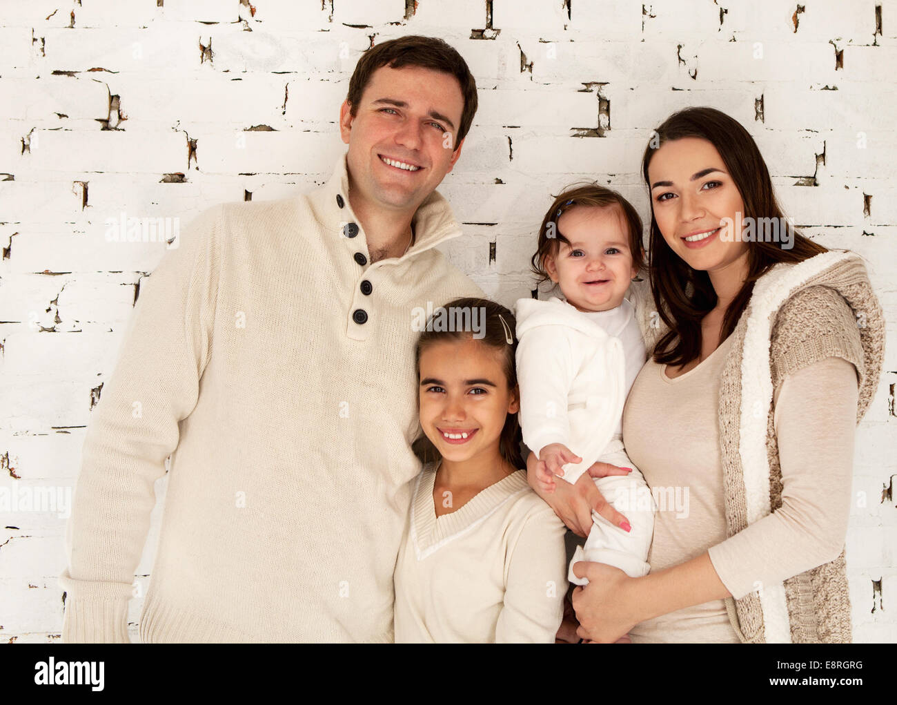 Portrait of a happy smiling family near white brick wall Stock Photo ...