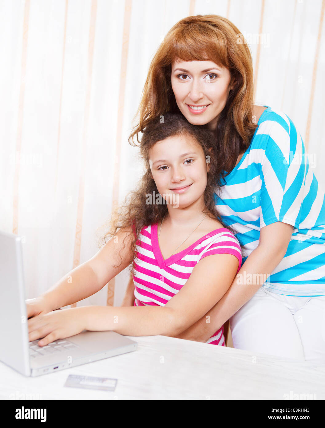 Young woman with daughter using laptop computer at home Stock Photo - Alamy