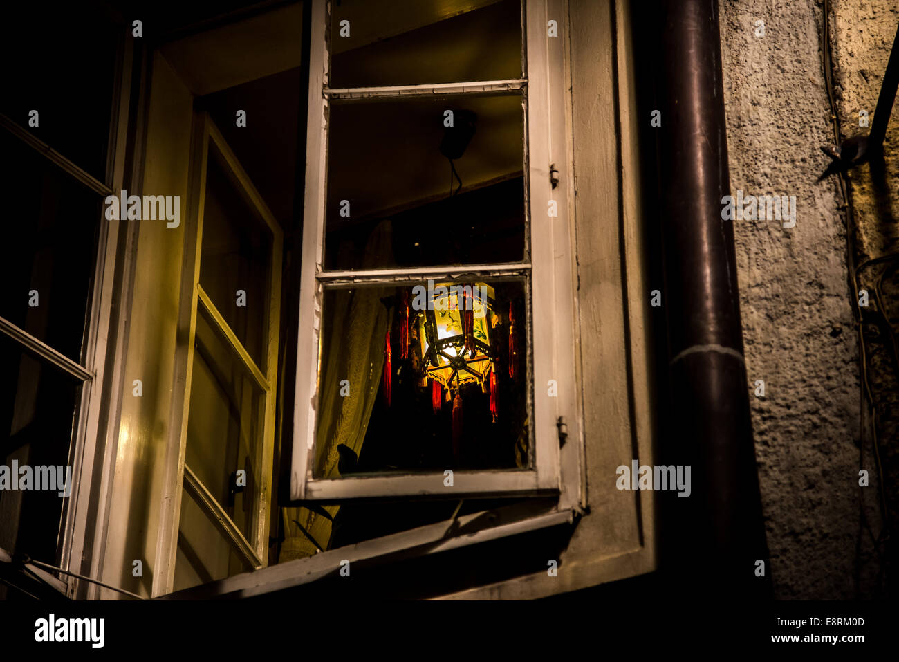 An ornate lamp hangs in an open window on a warm night Stock Photo - Alamy