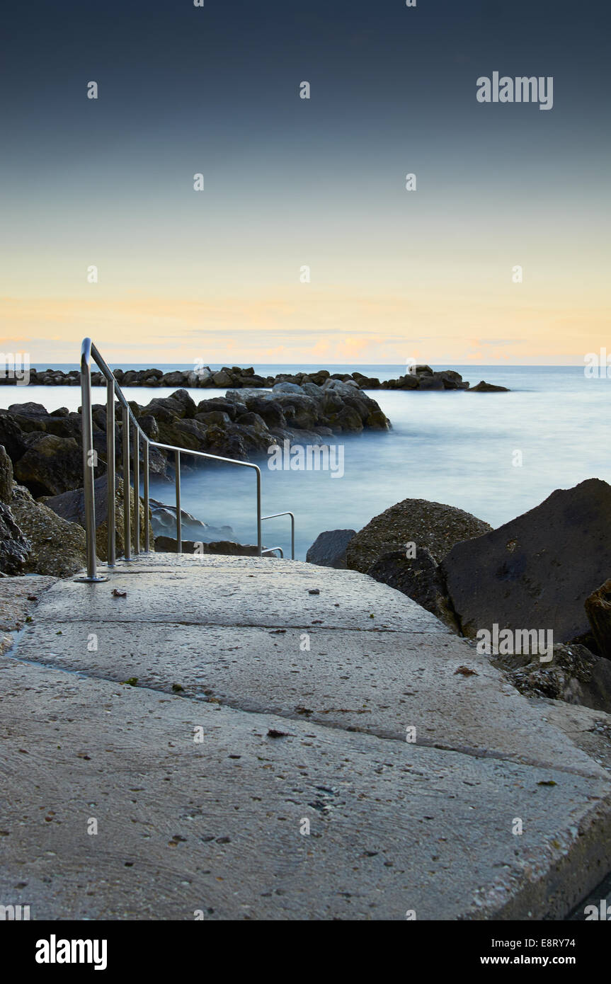 Sea wave impinges on an old stony rocky pier Stock Photo - Alamy