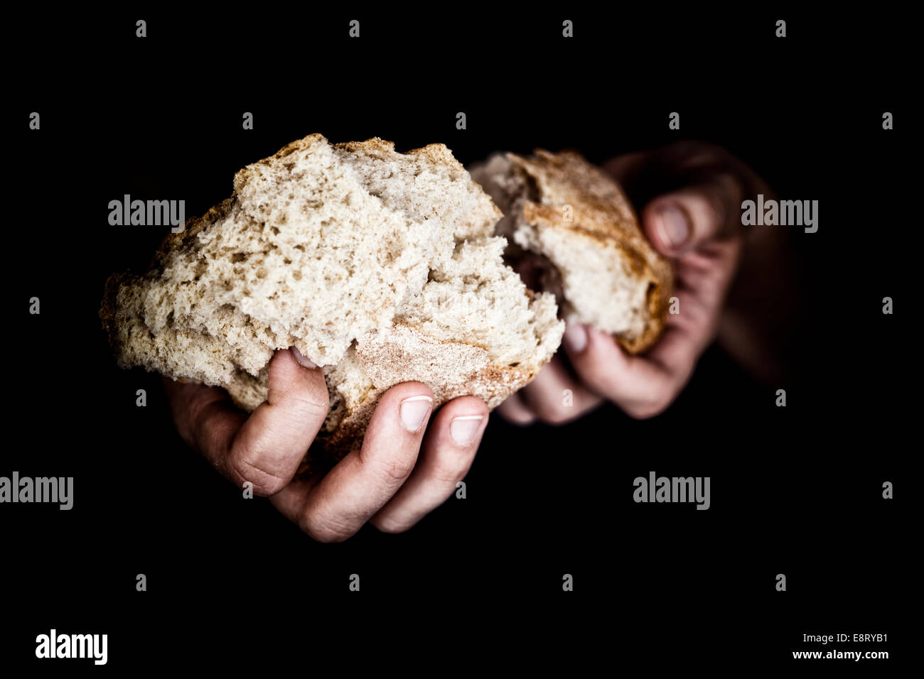 Woman's hands holding a pieces of bread. A helping hand concept ...