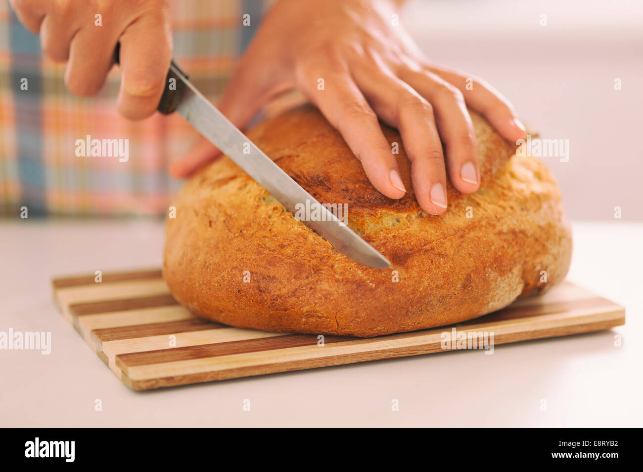 Woman's hands slicing bread Stock Photo - Alamy