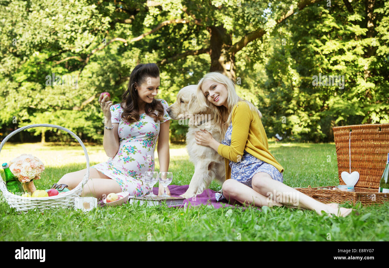 Portrait of the cheerful girlfriends hugging friendly dog Stock Photo ...