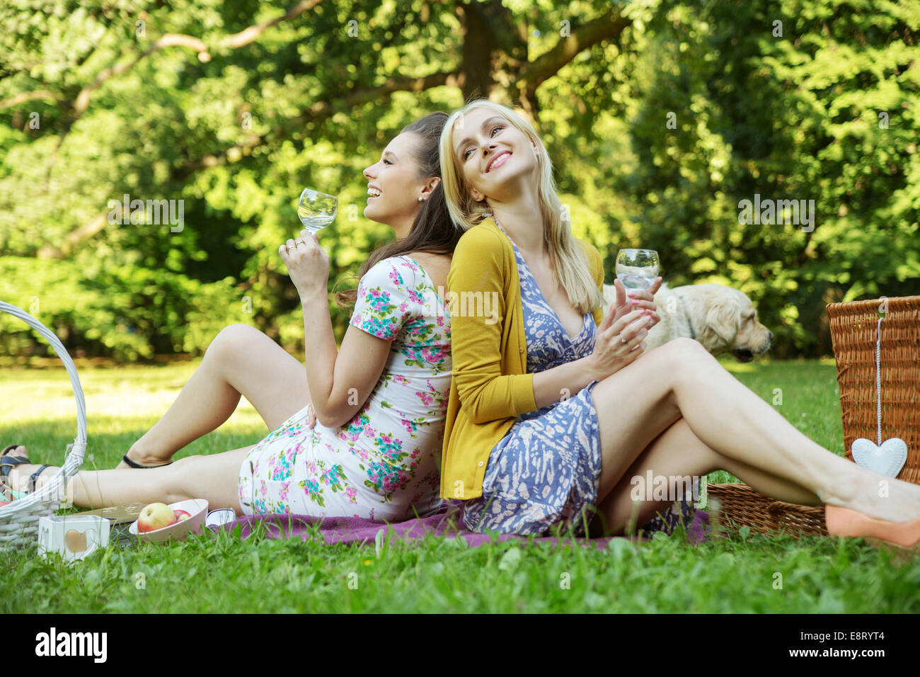 Two joyful ladies sitting on the blanket Stock Photo - Alamy