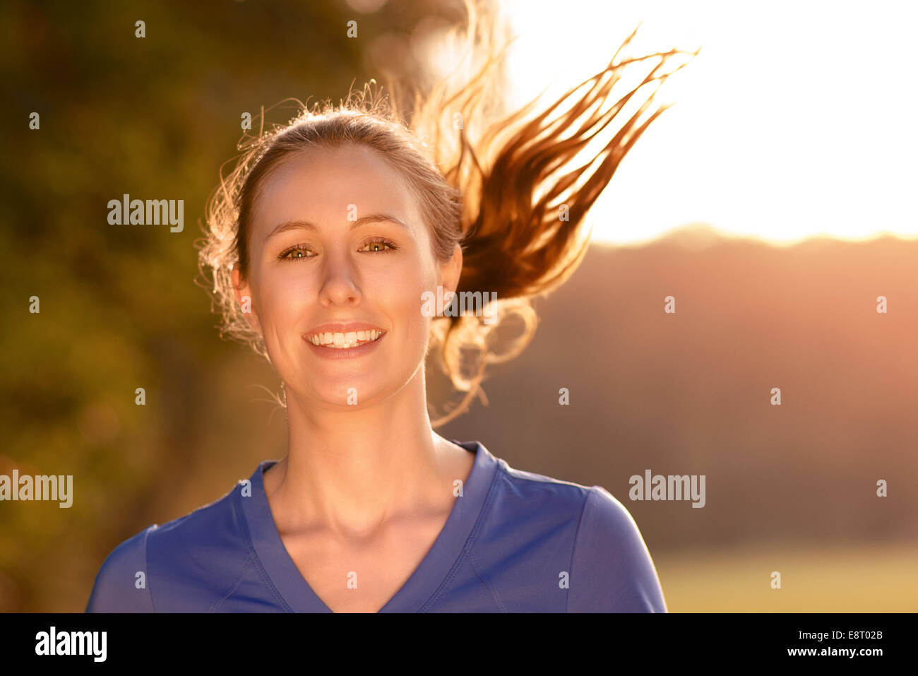 Attractive active young woman out exercising in glowing morning light ...