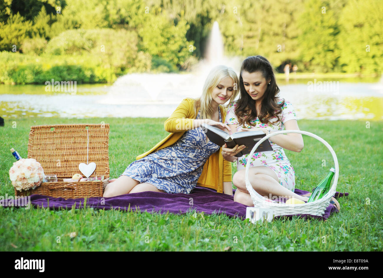 Two women reading book in the colorful park Stock Photo - Alamy