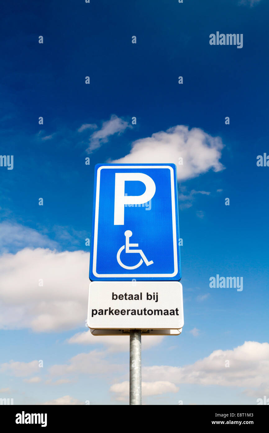 Blue handicapped parking sign for disabled drivers against a dramatic ...