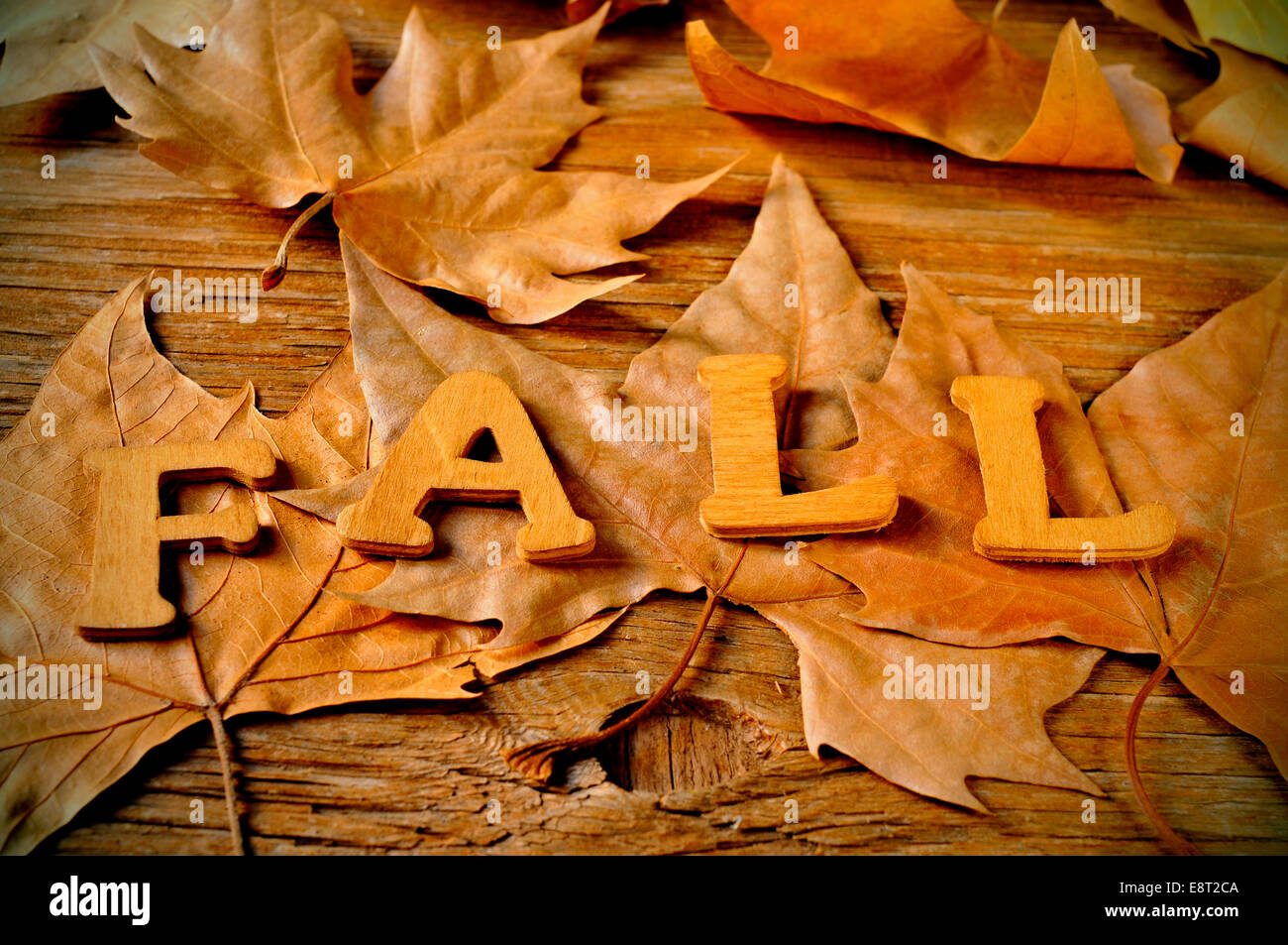 wooden letters forming the word fall and some autumn leaves on a ...